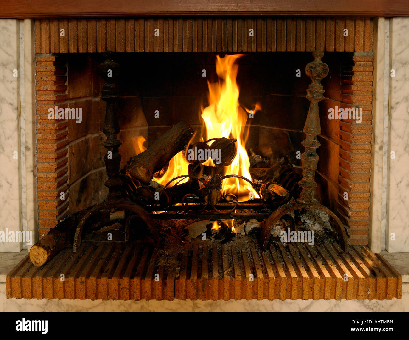 Log fire burning in fireplace with red brick surround Stock Photo - Alamy