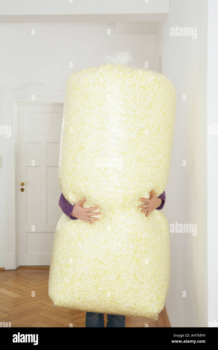 Young woman carrying large bag of packing foam Stock Photo - Alamy