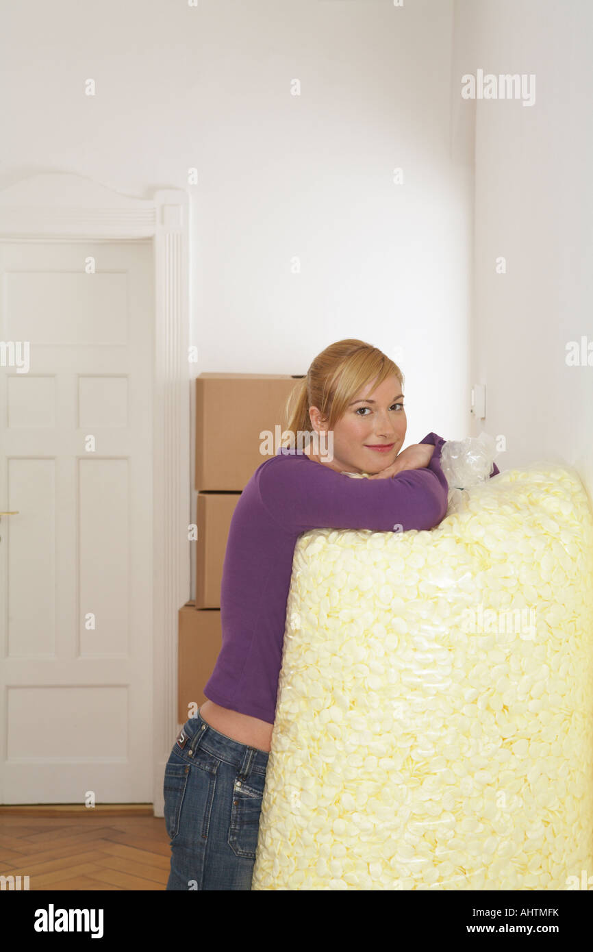 Young woman leaning on large bag of packing foam, portrait Stock Photo ...