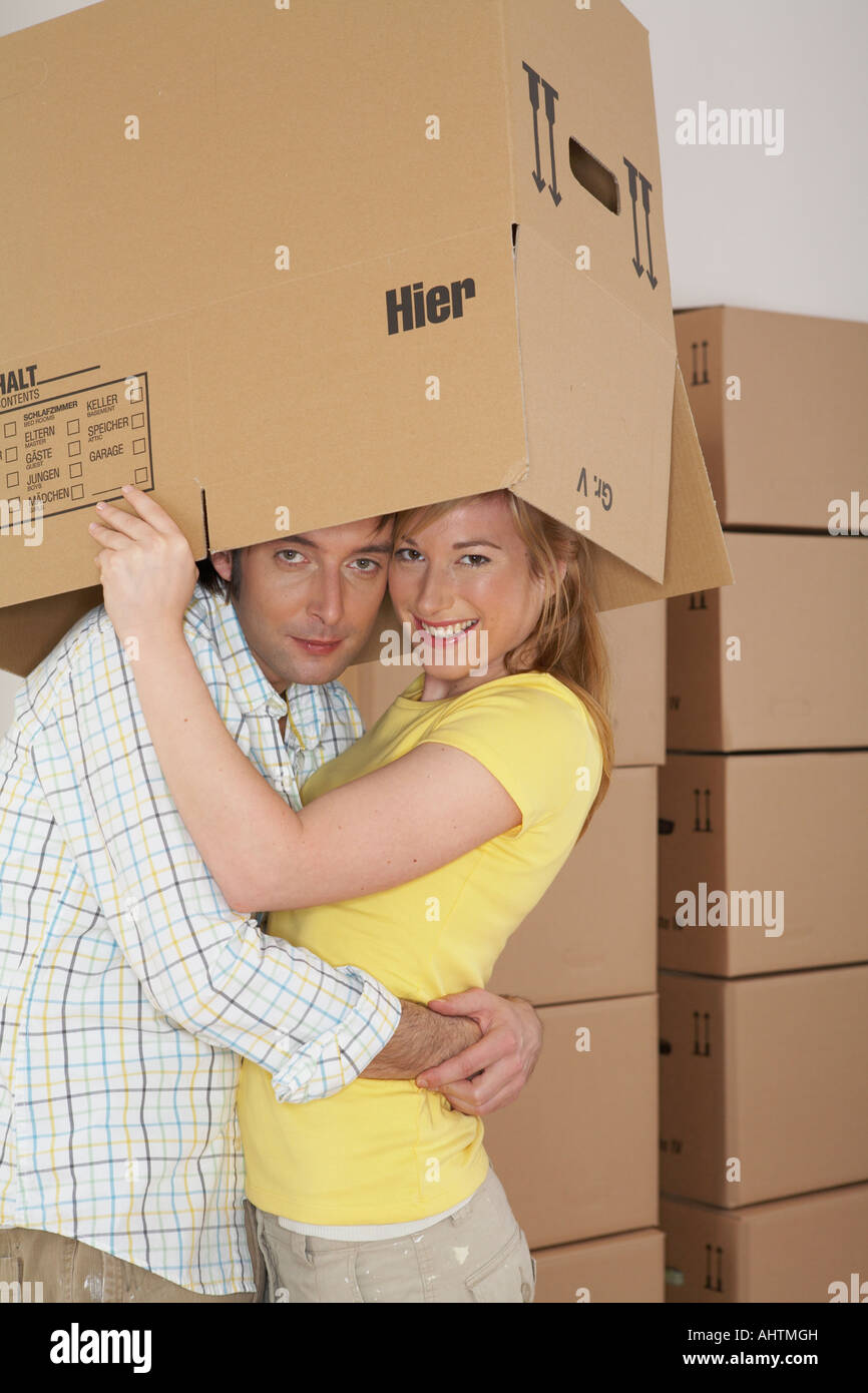 Young couple embracing under cardboard box, smiling, portrait Stock ...