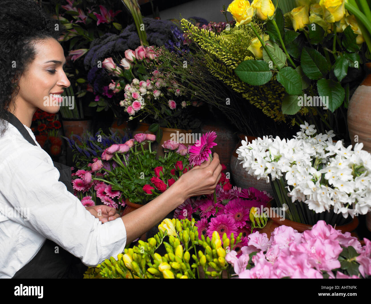 Young female florist selecting flower, smiling, profile Stock Photo - Alamy