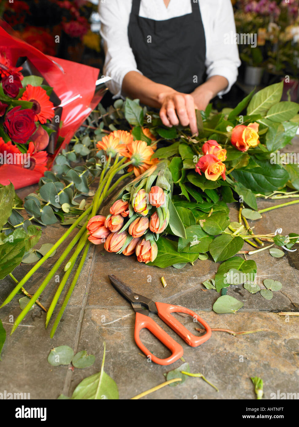 Young female florist preparing bouquet in shop, mid section Stock Photo ...