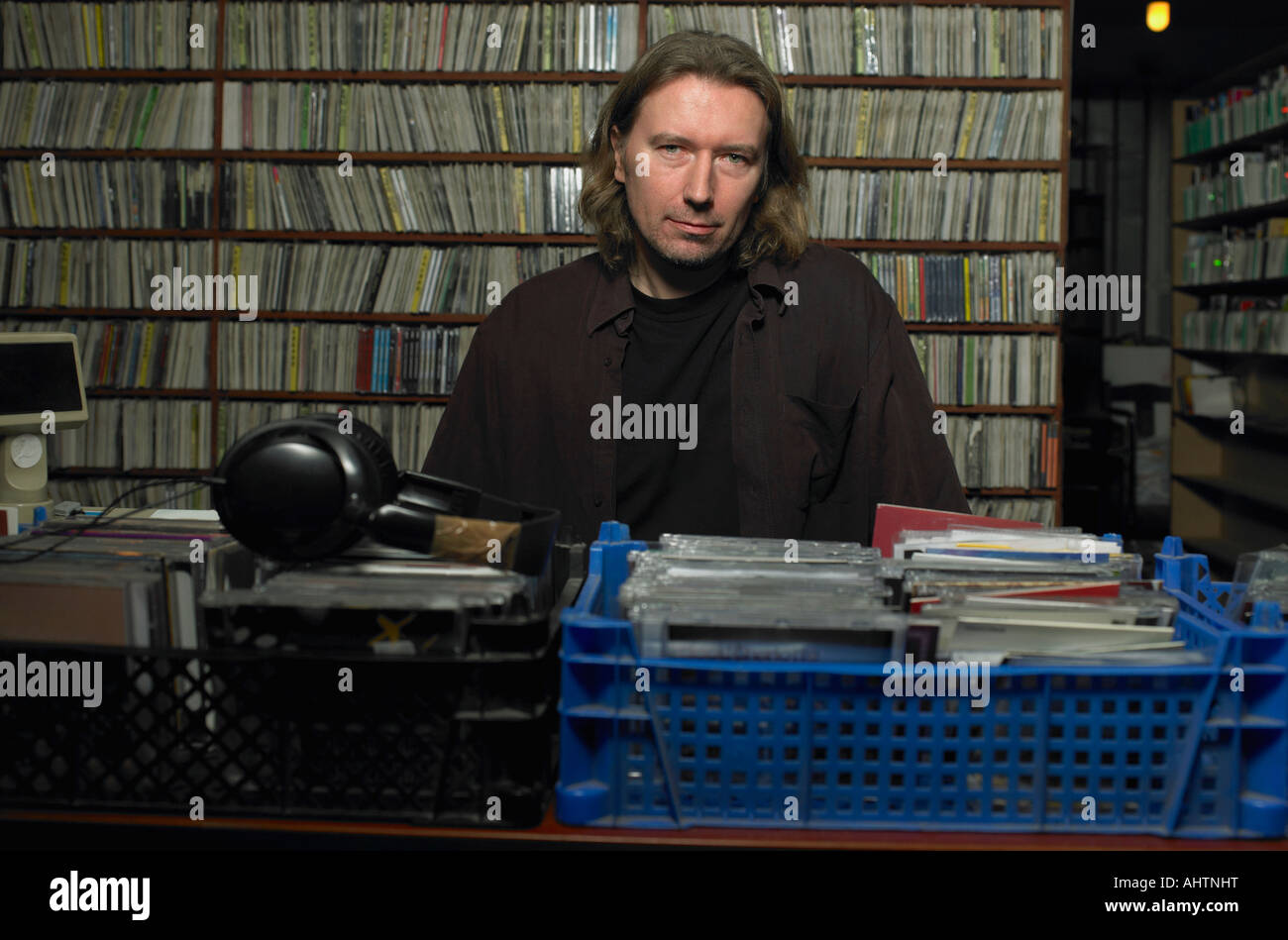 Mature man behind counter in music shop, portrait Stock Photo - Alamy