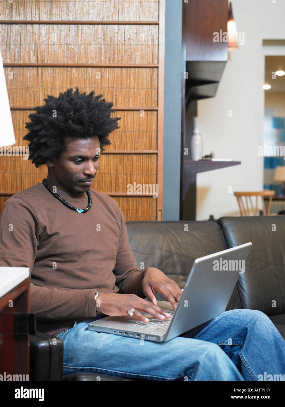 Man sitting on sofa using laptop Stock Photo - Alamy