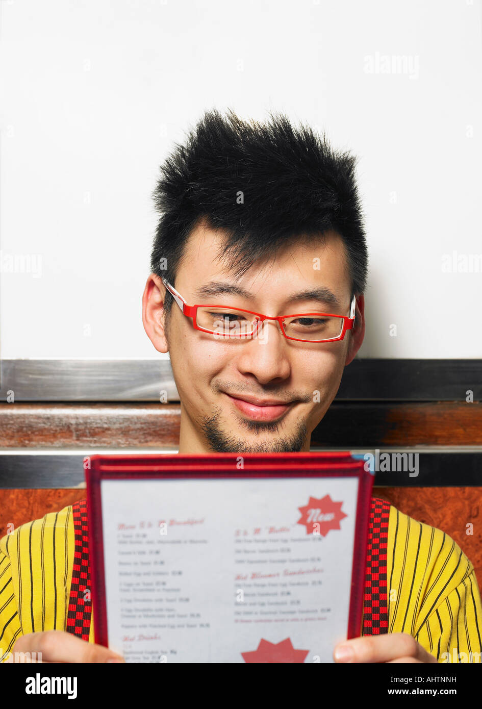 Young man looking at cafe menu, smiling, close-up Stock Photo - Alamy