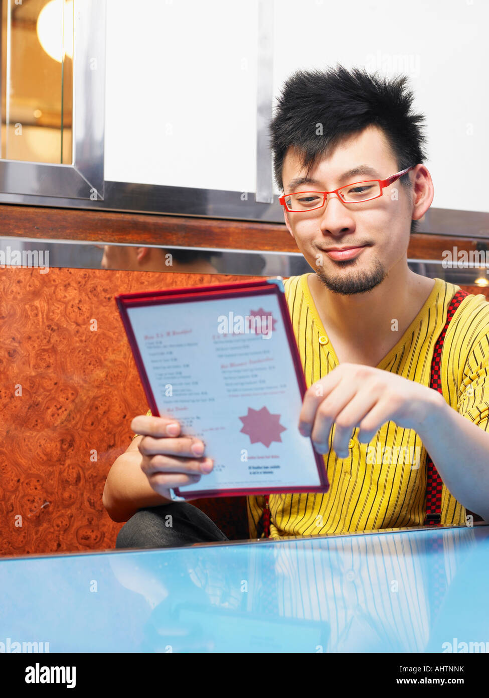 Young man looking at cafe menu, smiling, close-up Stock Photo - Alamy