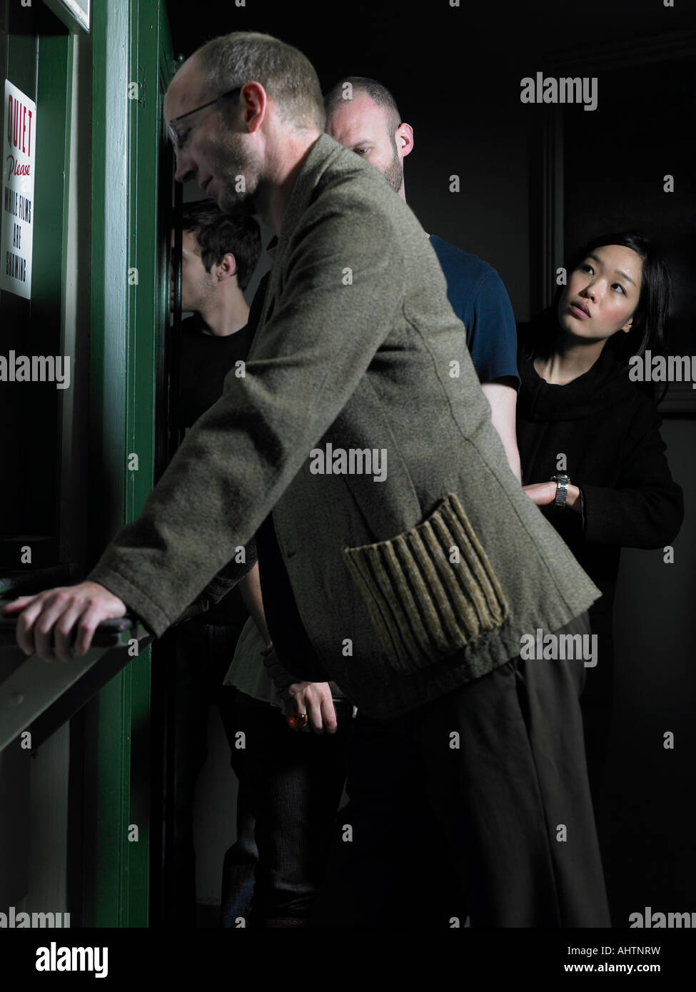 Man at counter, woman checking time in queue in background Stock Photo ...