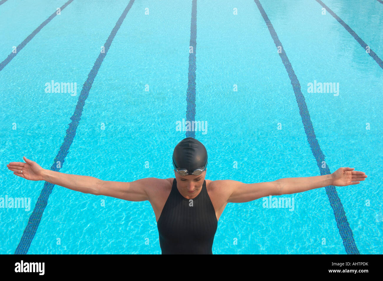 Female swimmer standing with arms outstretched by pool Stock Photo - Alamy
