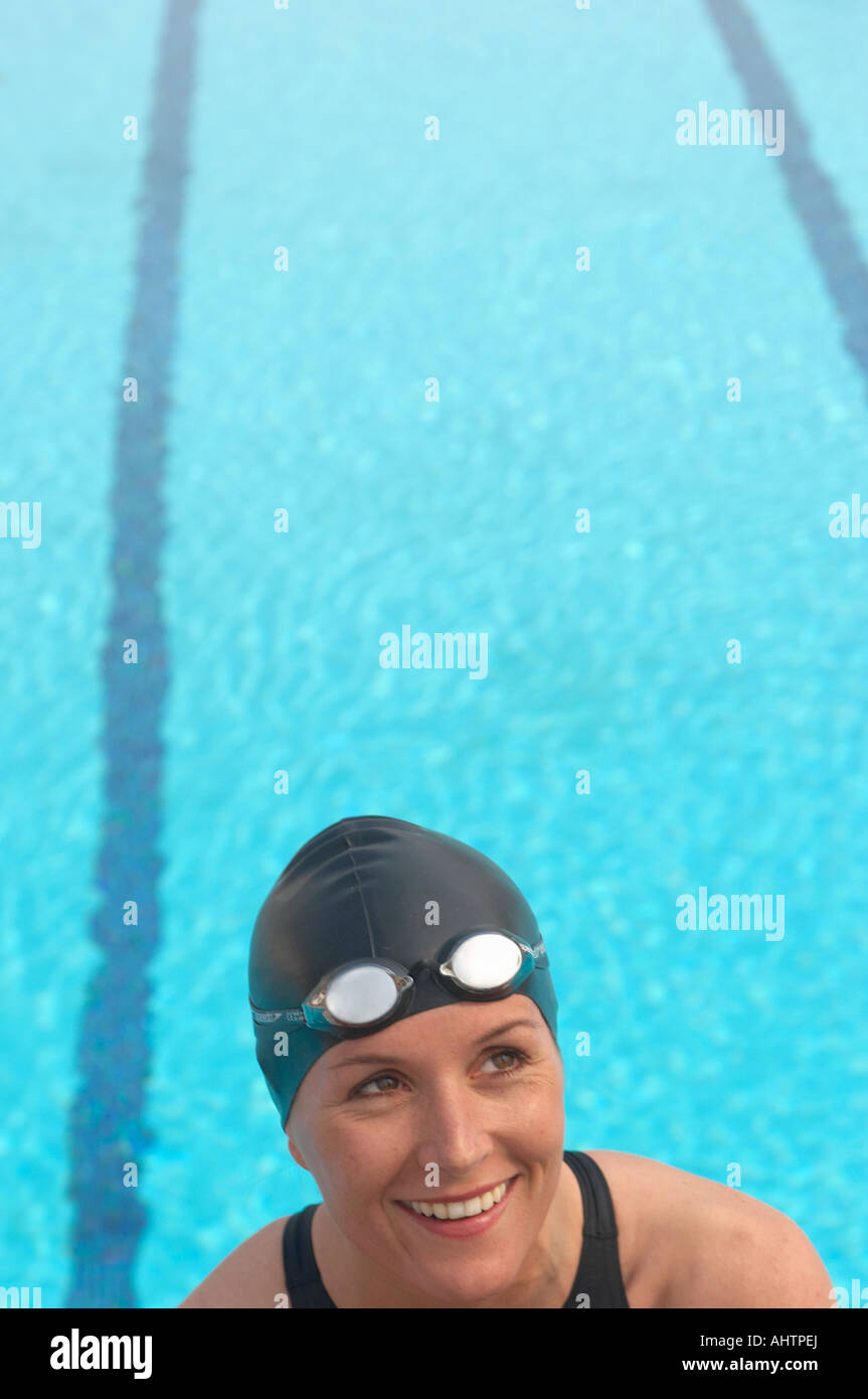 Female swimmer by pool, smiling Stock Photo - Alamy