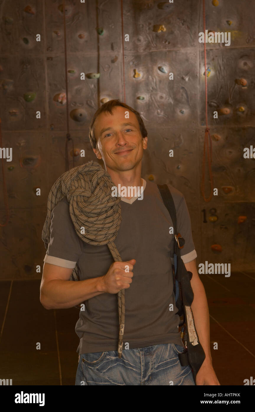 Man holding rope standing in climbing centre, smiling, portrait Stock ...