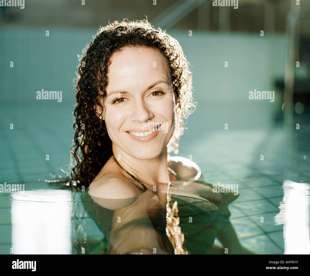 Woman standing in swimming pool, smiling, portrait Stock Photo - Alamy