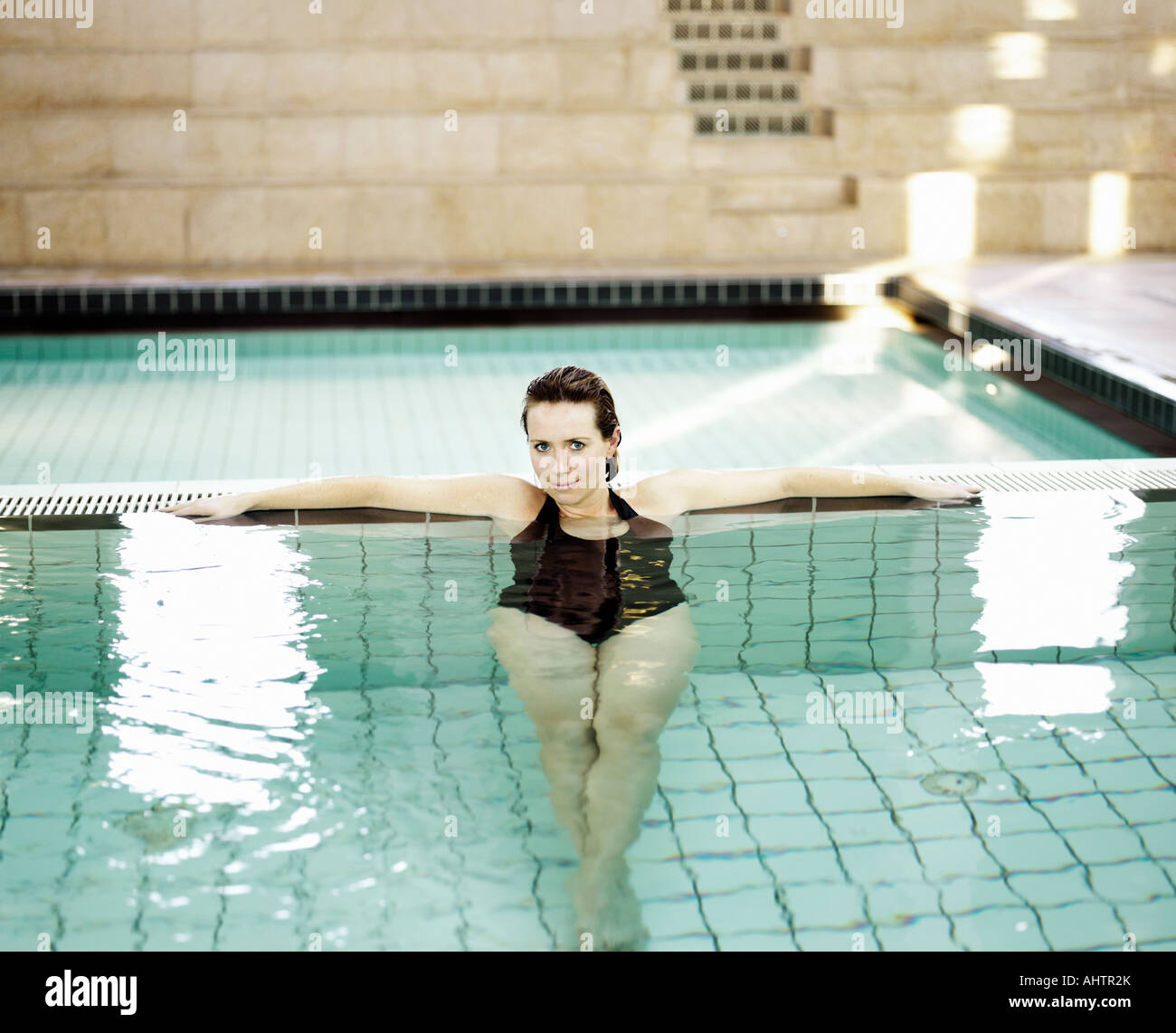 Woman standing in swimming pool, smiling, portrait Stock Photo - Alamy