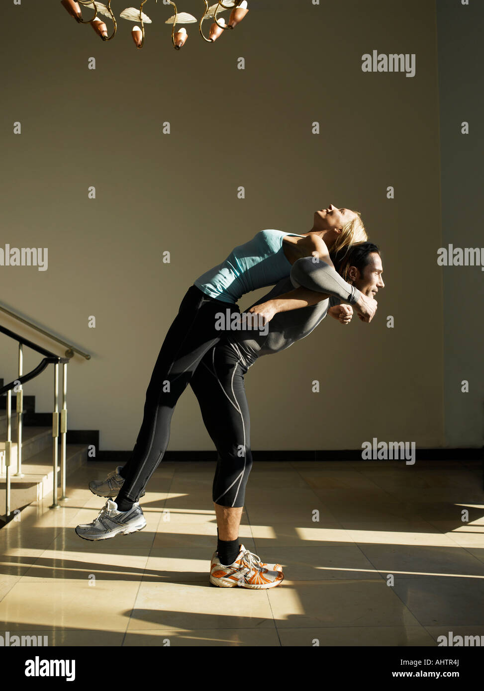 Man helping woman stretch back, side view Stock Photo - Alamy