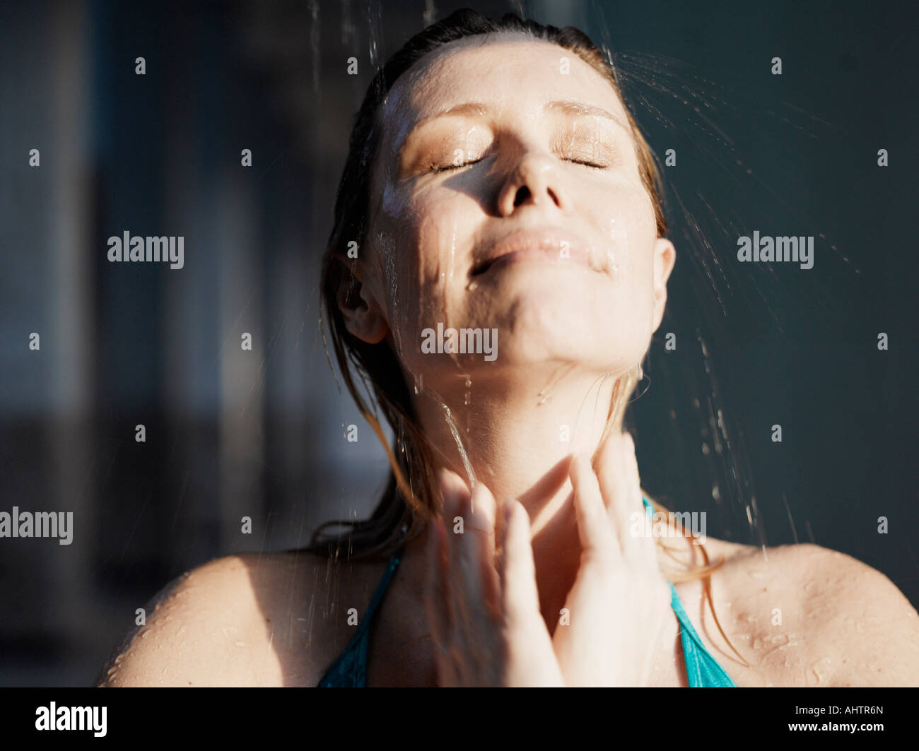 Woman beneath shower, eyes closed Stock Photo - Alamy