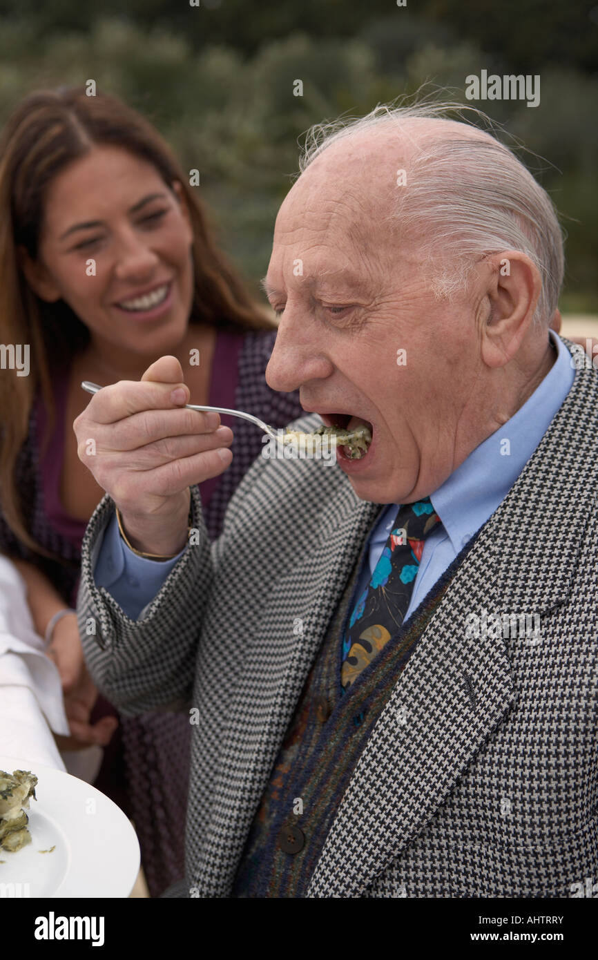 Senior man eating at table outdoors Stock Photo - Alamy