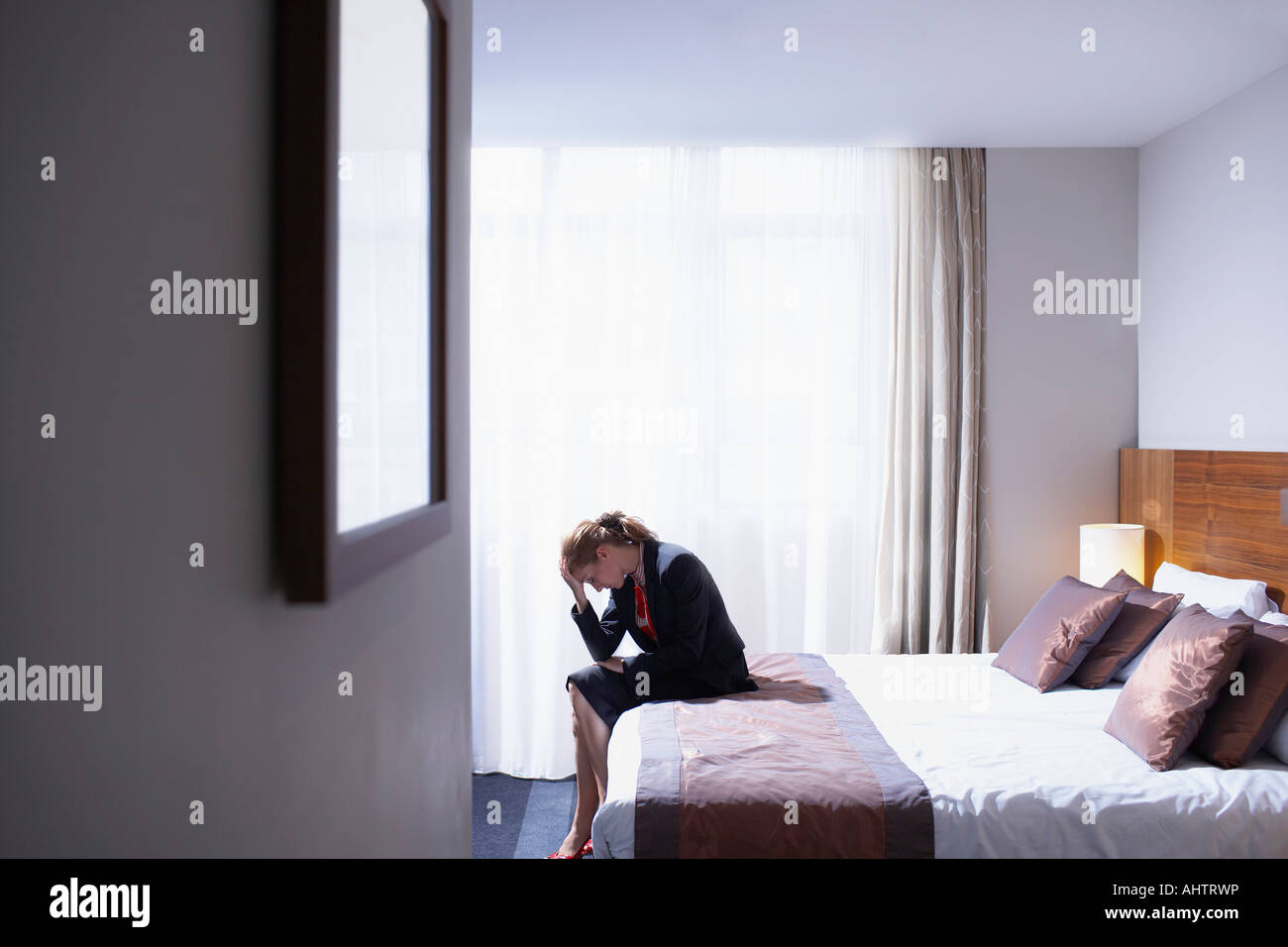 Sad woman sitting on bed edge hi-res stock photography and images - Alamy