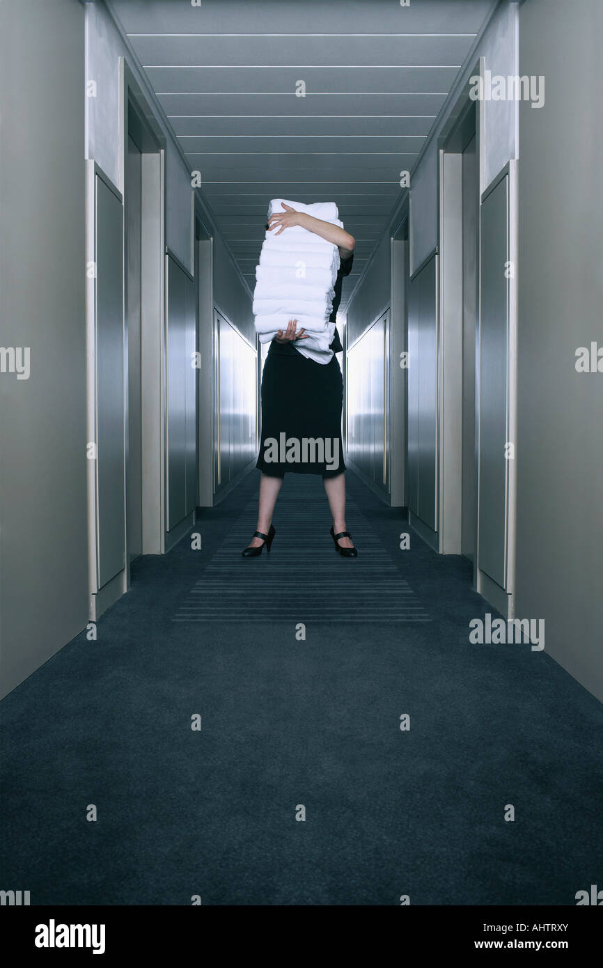 Housekeeper carrying a stack of towels Stock Photo - Alamy