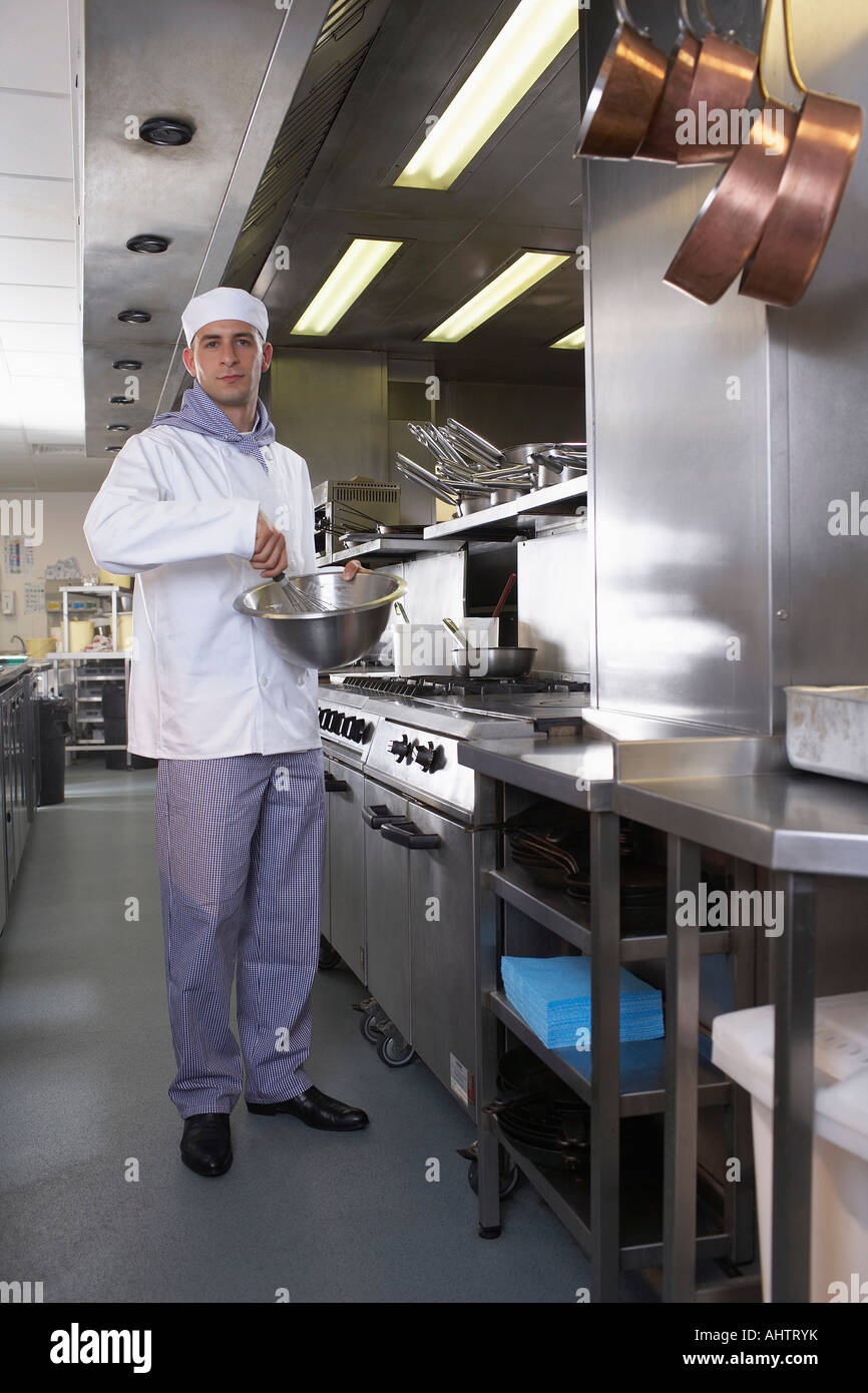 Chef beating food in bowl in kitchen Stock Photo - Alamy