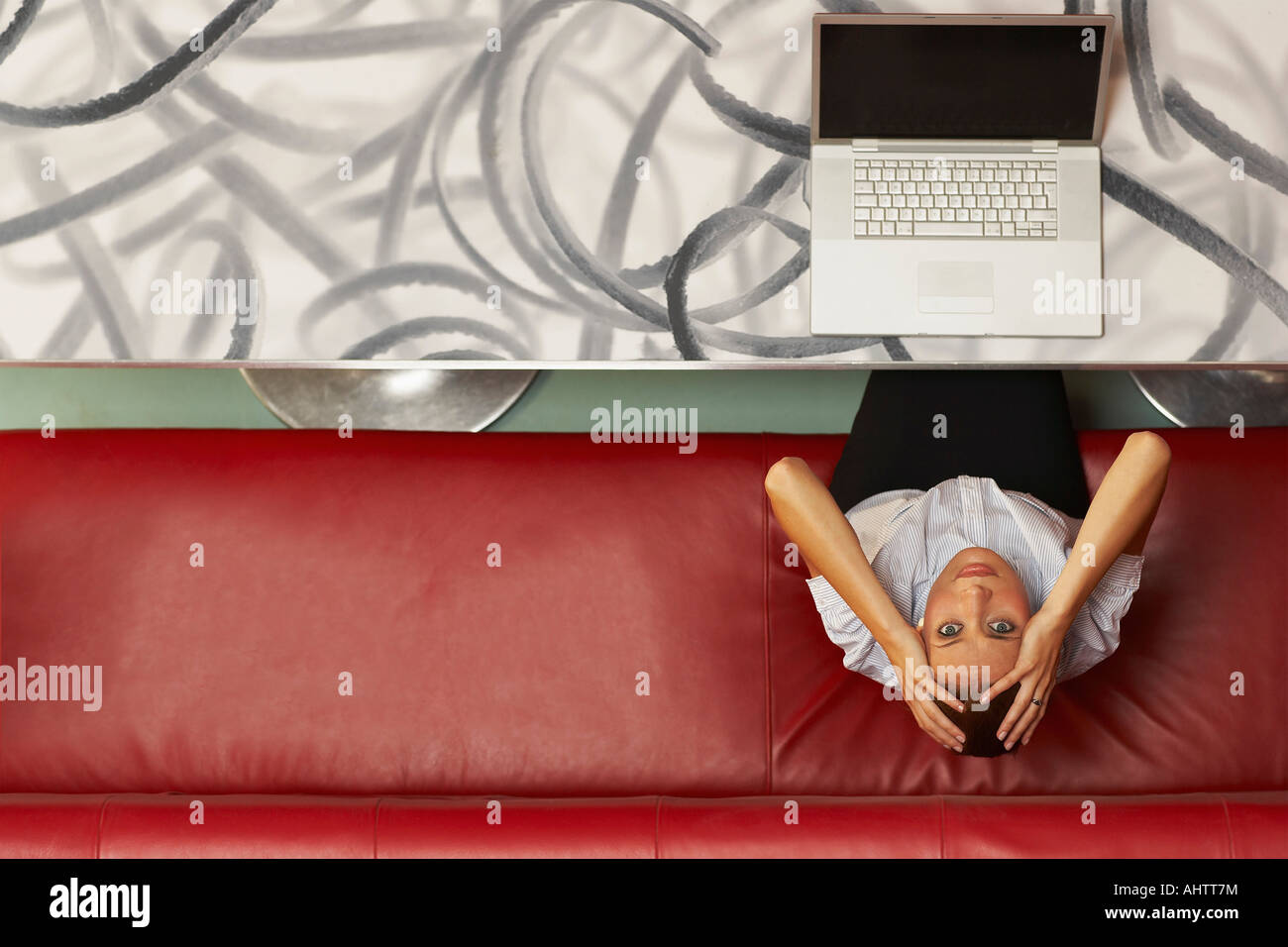 Businesswoman working at a table with red seating Stock Photo - Alamy