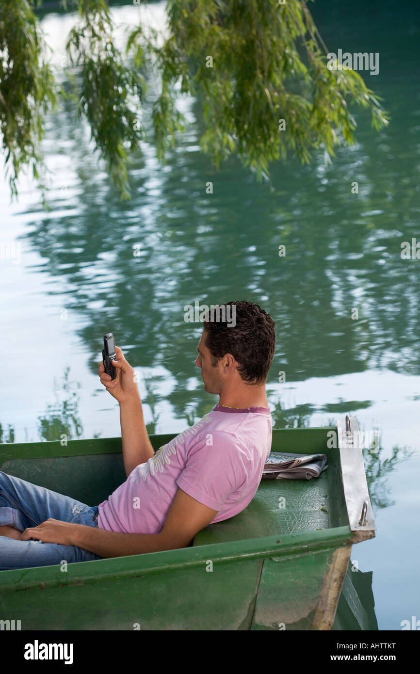 Man using a cell phone on boat Stock Photo - Alamy