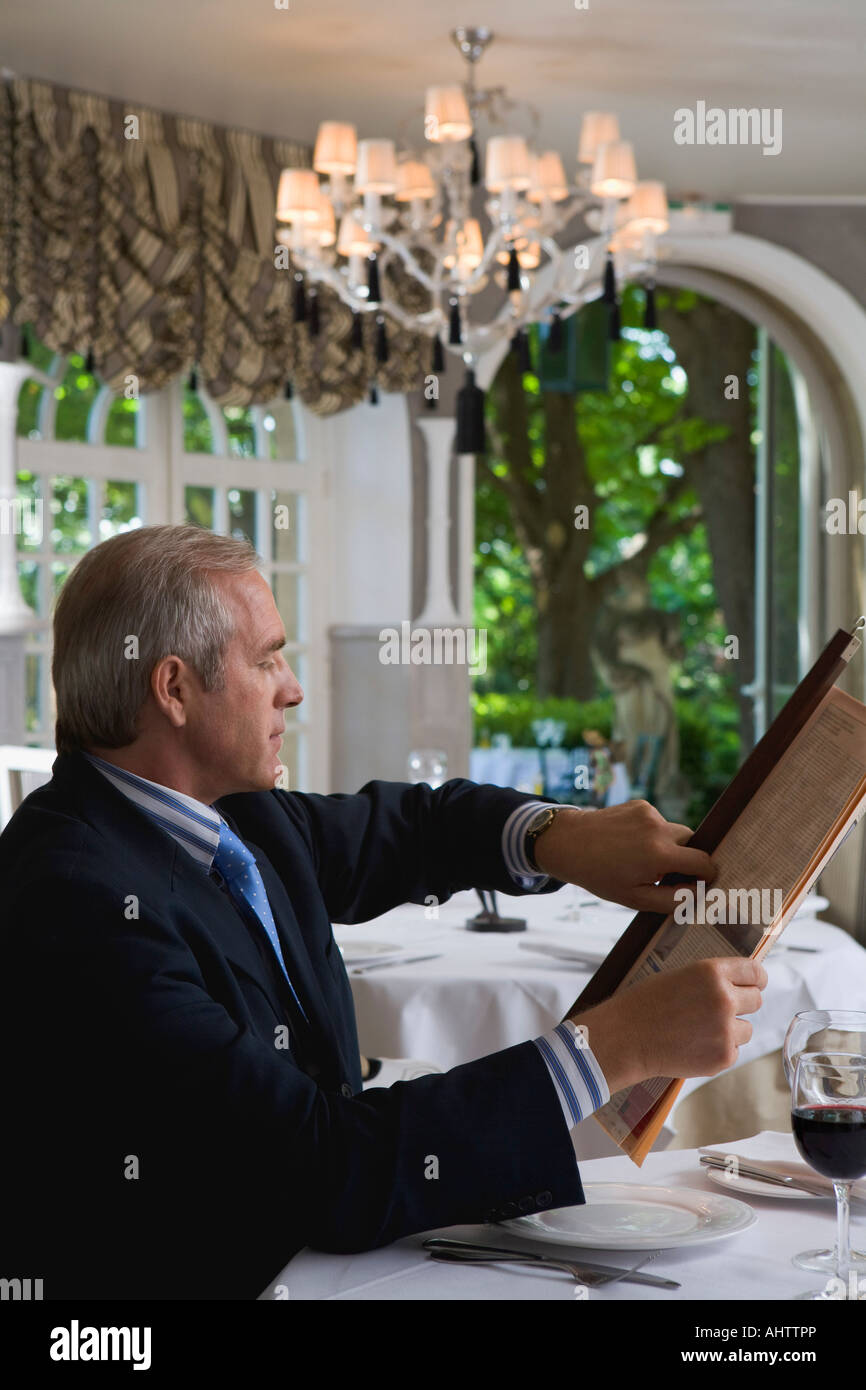 Businessman looking at watch in a restaurant Stock Photo - Alamy