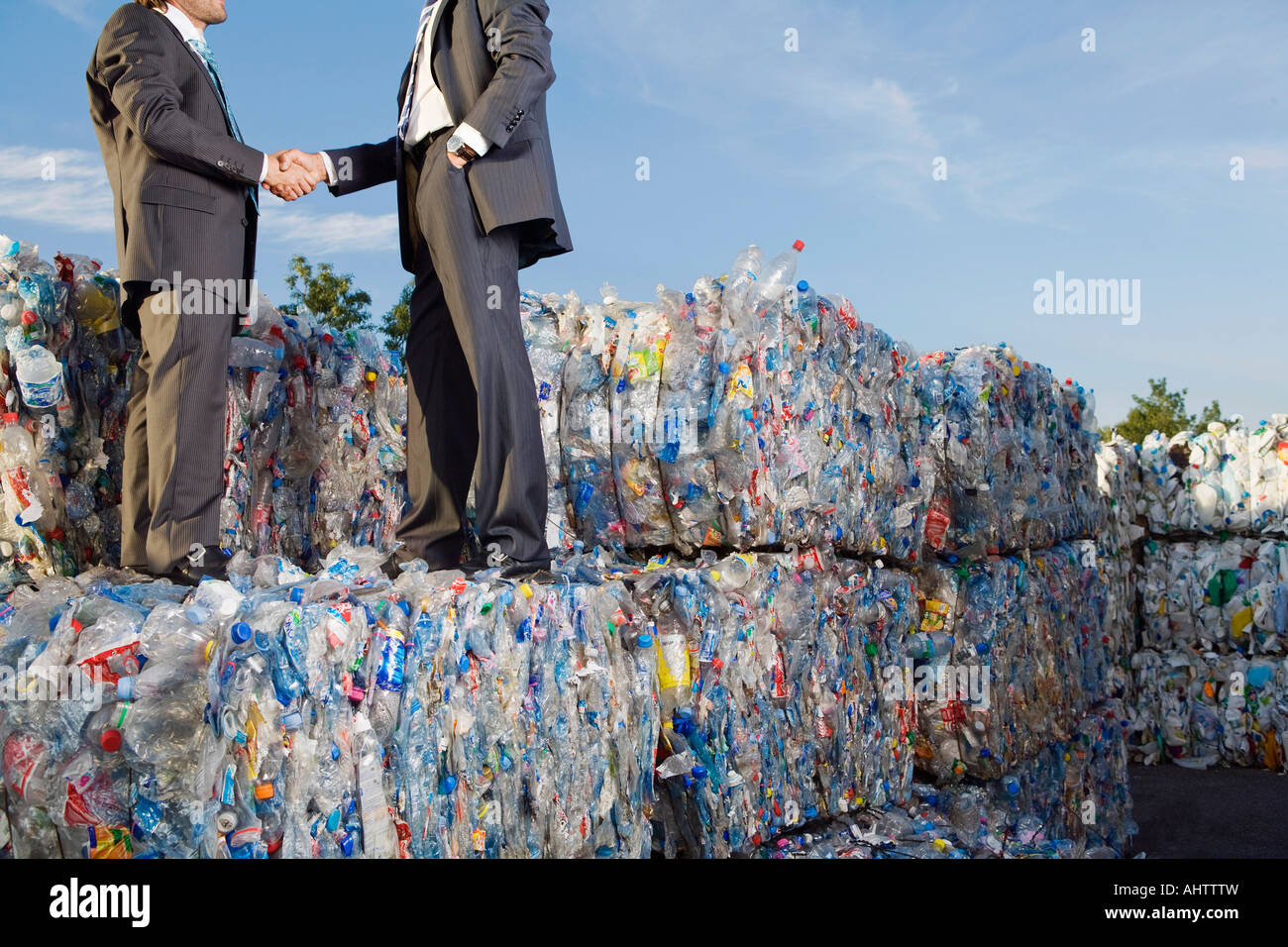 Businessmen shaking hands at a recycling plant Stock Photo - Alamy
