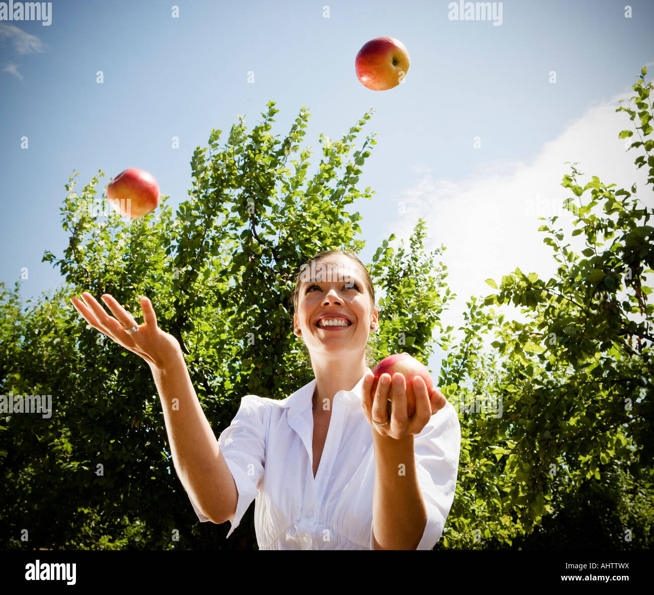 Woman juggling apples in orchard Stock Photo - Alamy