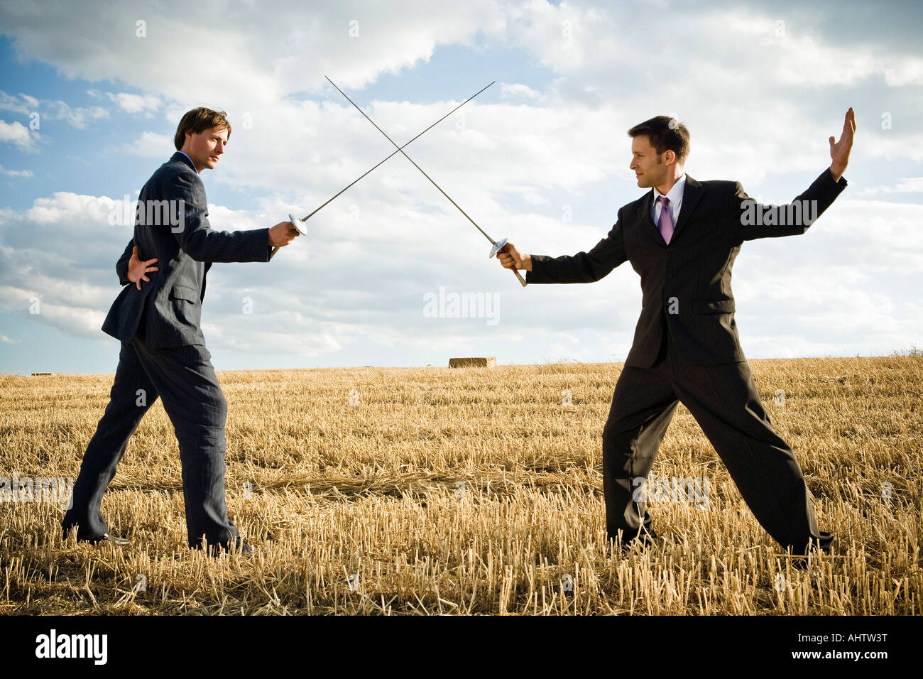 Businessmen fencing in wheat field Stock Photo - Alamy
