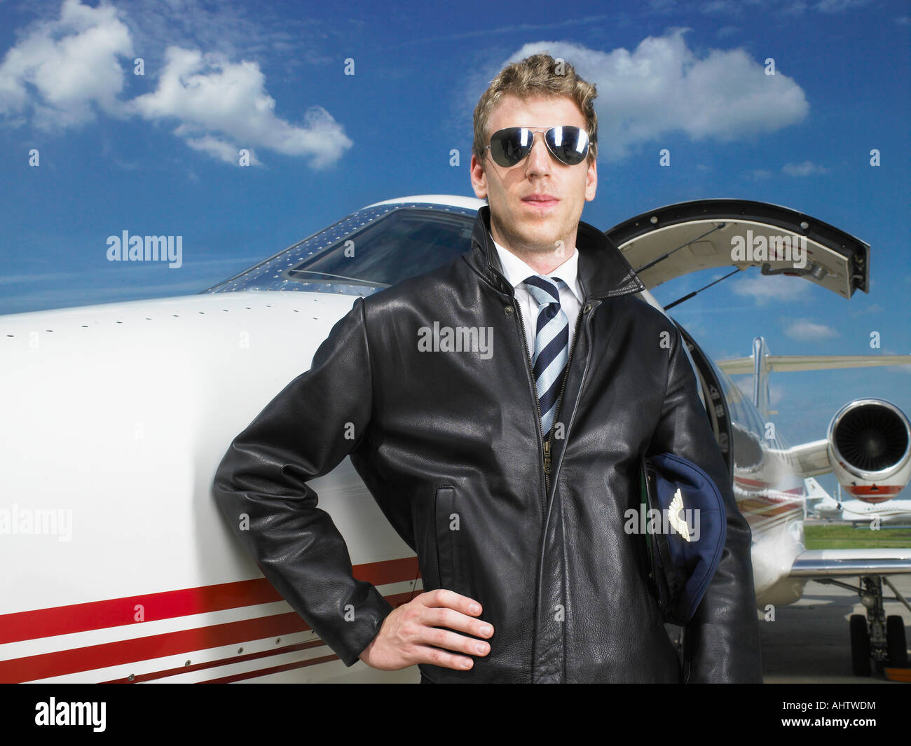 Pilot standing beside private jet Stock Photo - Alamy