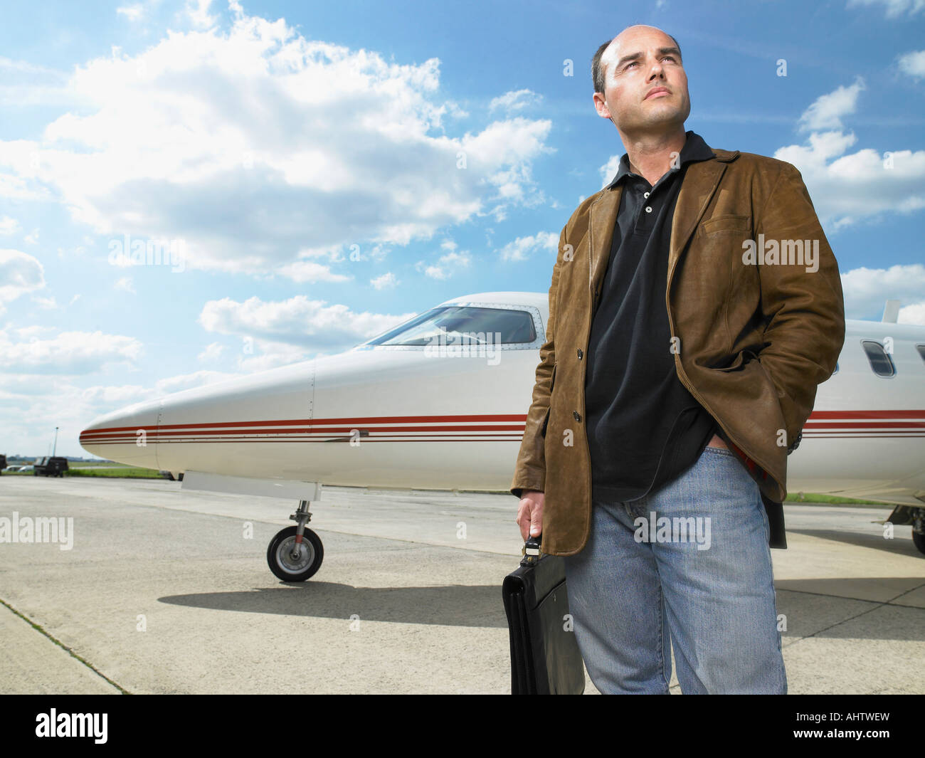 Man standing next to private jet Stock Photo - Alamy