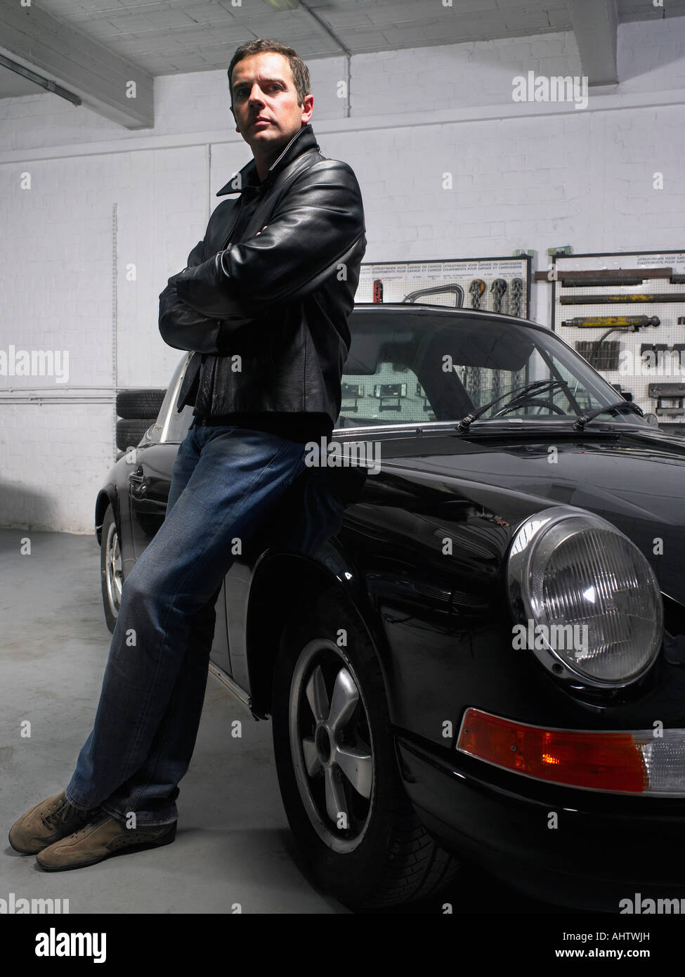 Man leaning on a Porsche in a garage Stock Photo - Alamy
