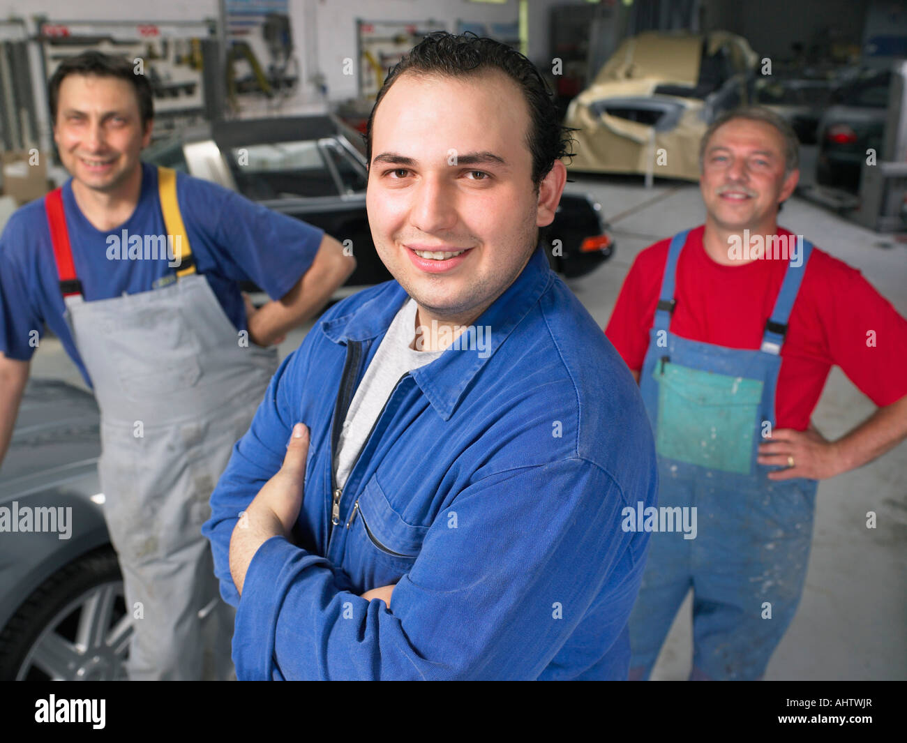 Three workers in a garage portrait Stock Photo - Alamy