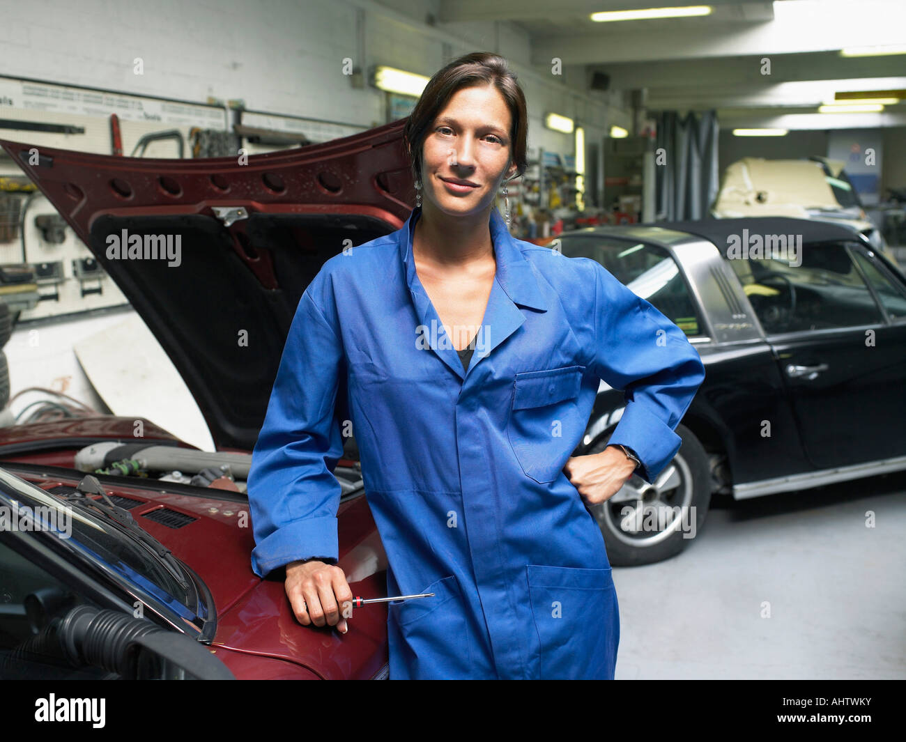 Female worker in front of an open trunk in a garage Stock Photo - Alamy