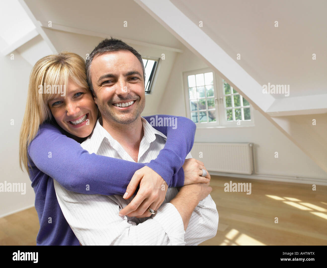 Happy couple in an embrace in empty loft Stock Photo - Alamy