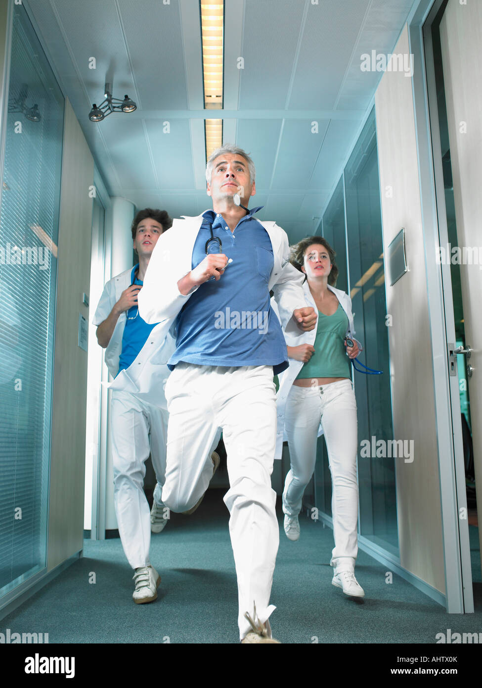Three doctors running in a lobby of a hospital Stock Photo - Alamy