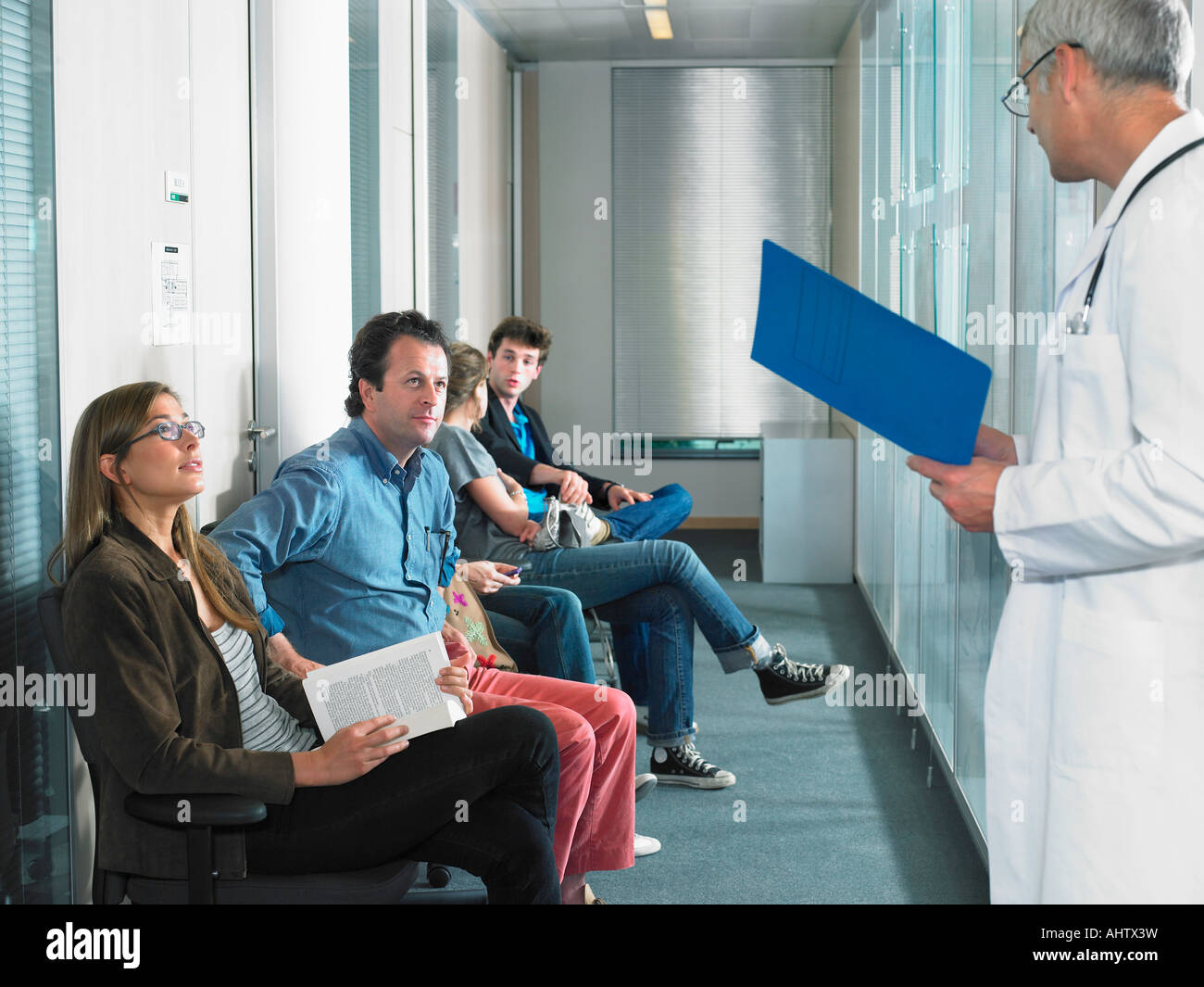 Male doctor calling for patients in hospital waiting room Stock Photo ...