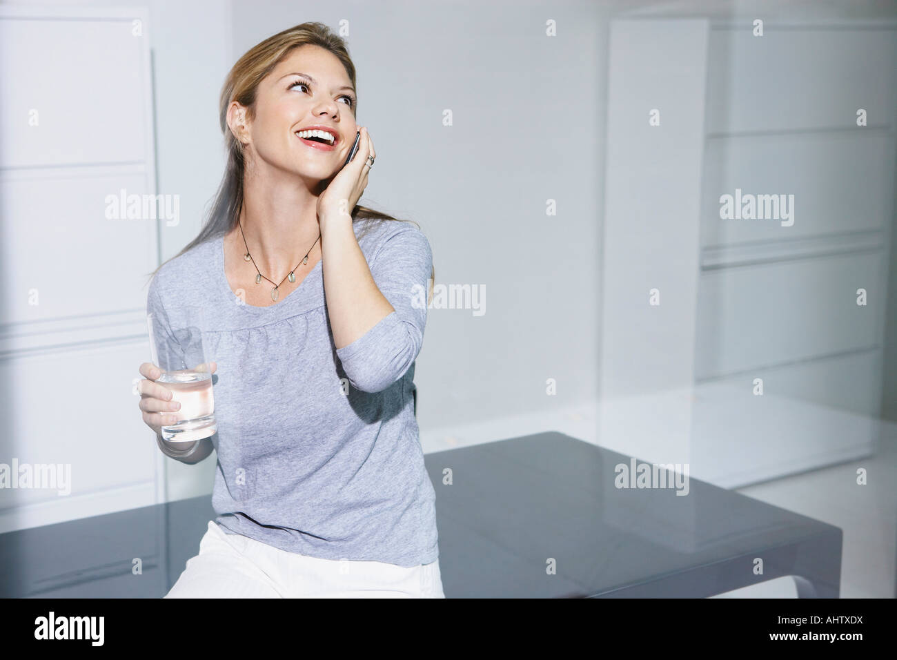 Woman on computer desk on cell phone Stock Photo - Alamy