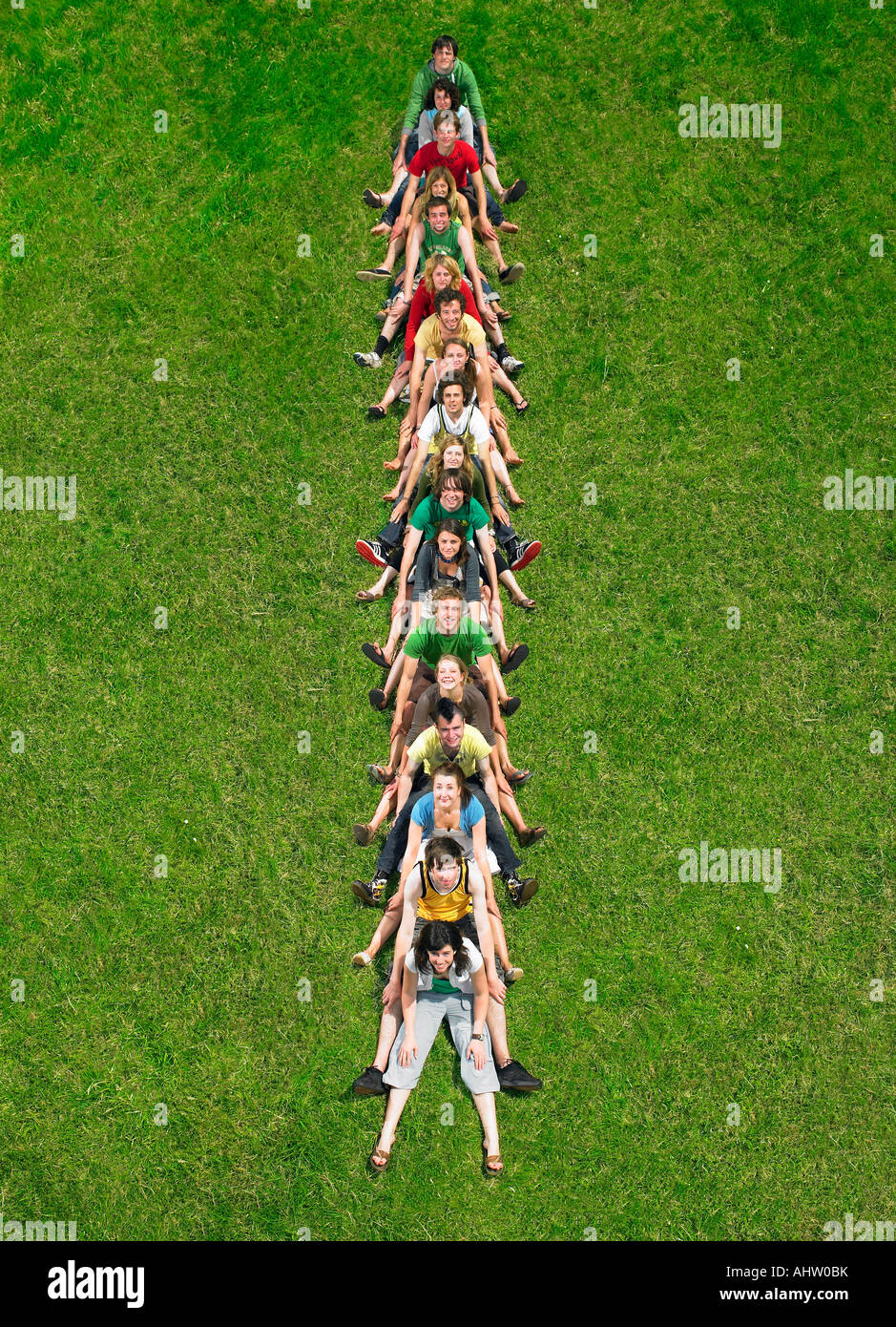 Group sitting in a line on the grass Stock Photo - Alamy