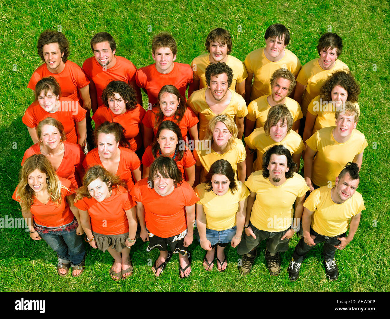 Group standing on grass half wearing orange half yellow Stock Photo - Alamy