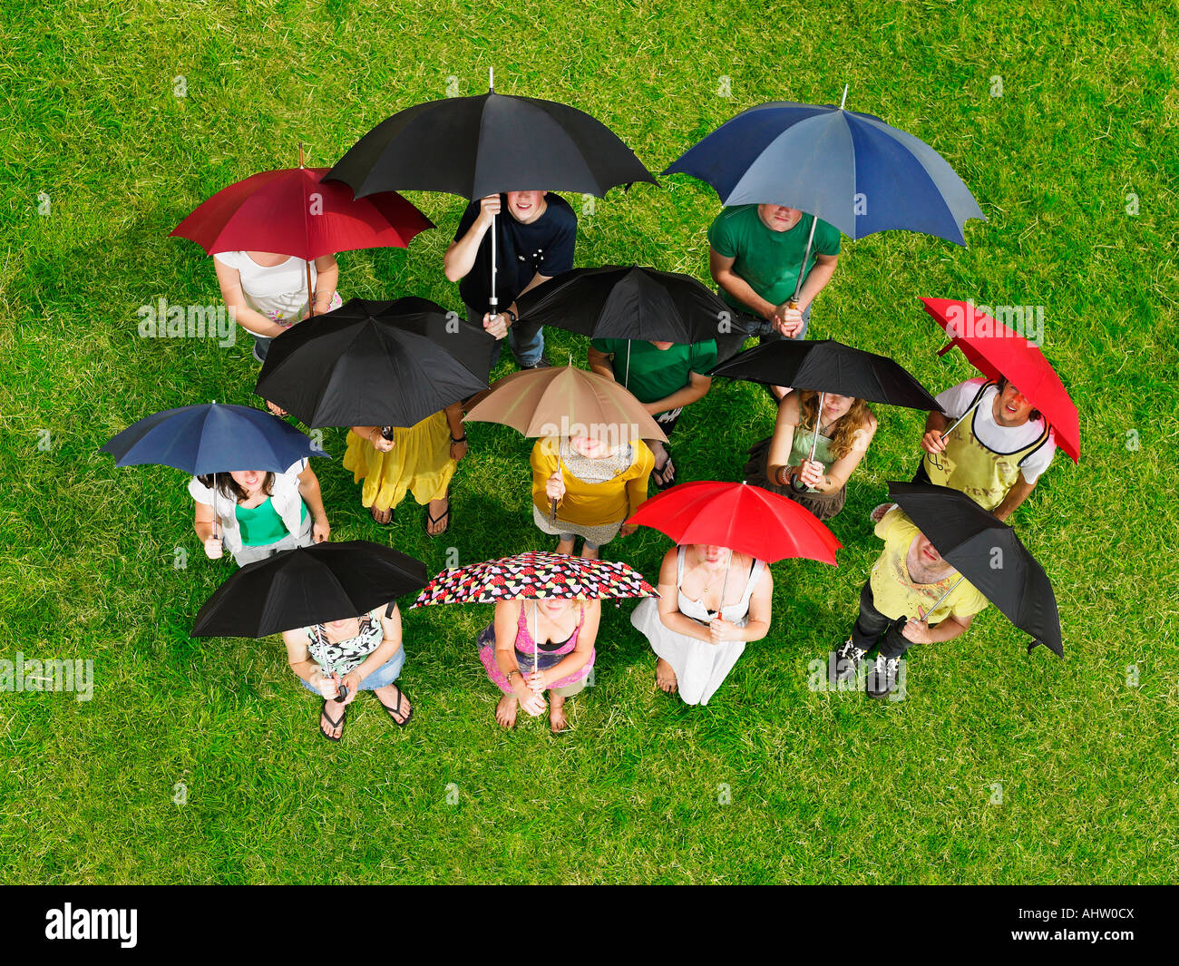 Group of people on grass holding umbrellas Stock Photo - Alamy