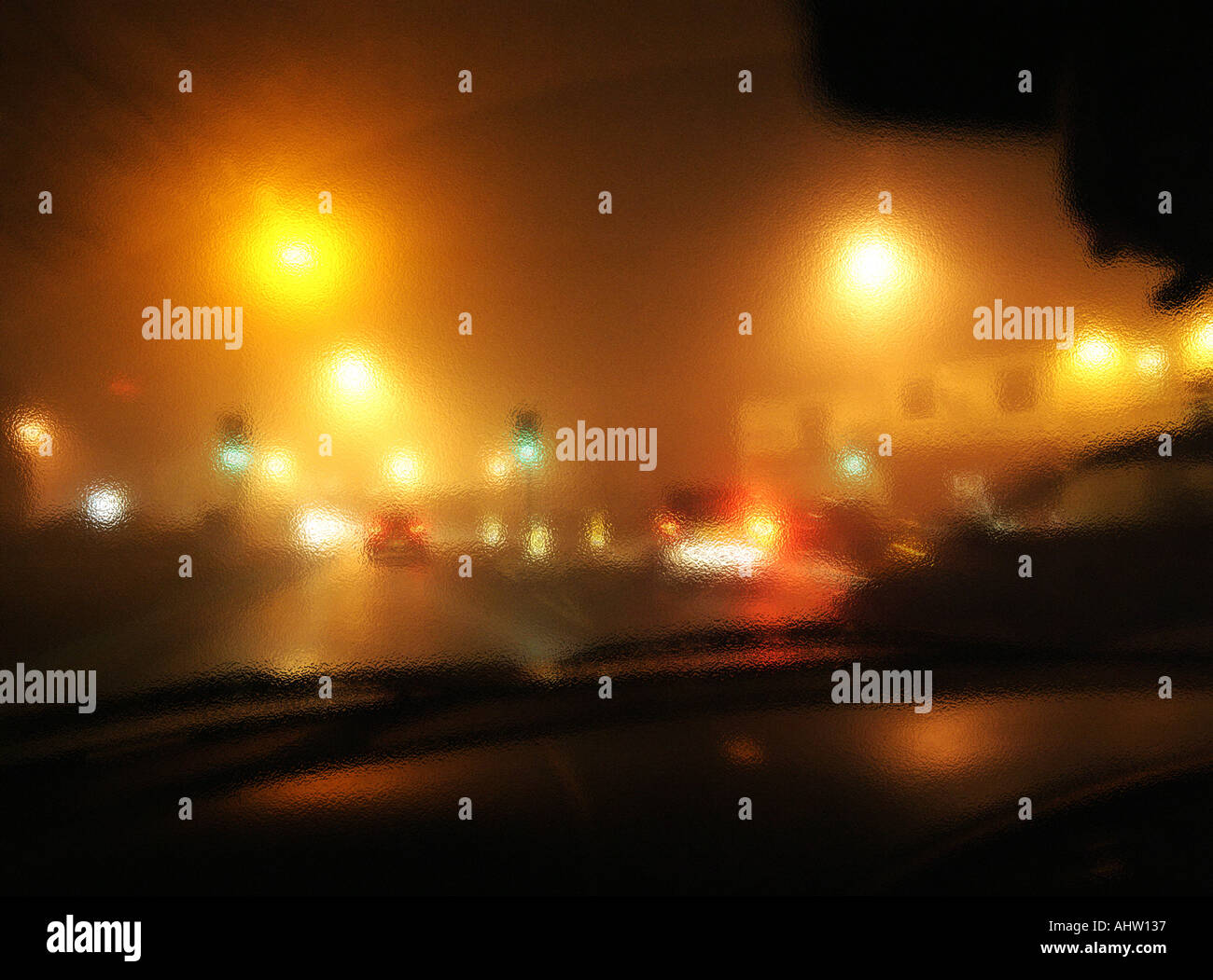 Hazy view through windscreen of a car at foggy luminescent streetlights ...