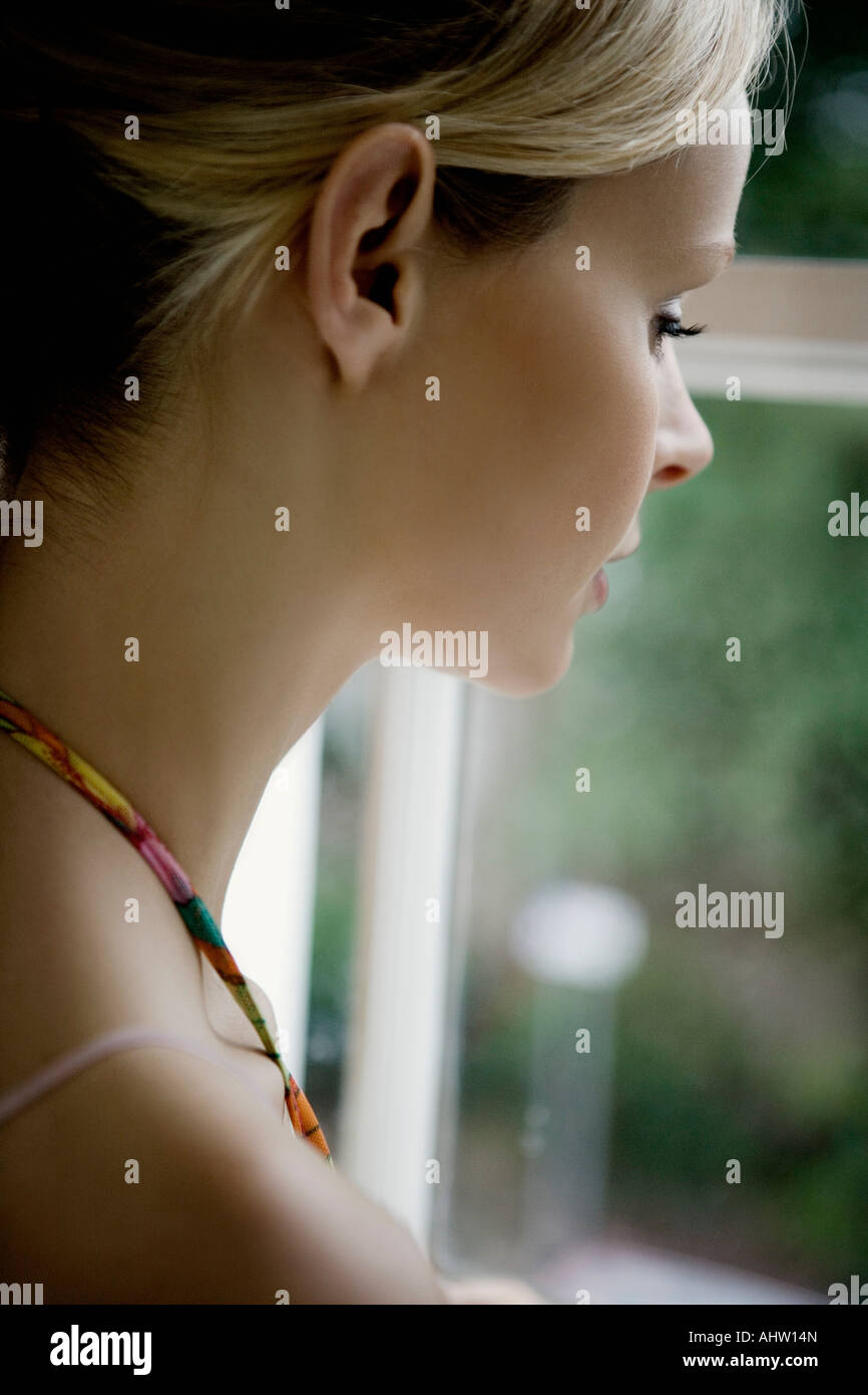 Woman looking out of window Stock Photo - Alamy