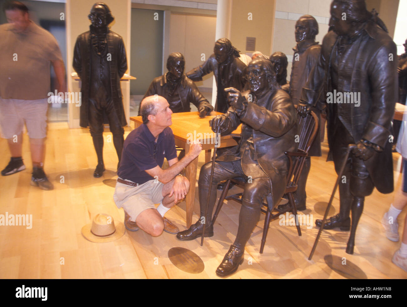 A tourist observing bronze replicas of the American founding fathers ...