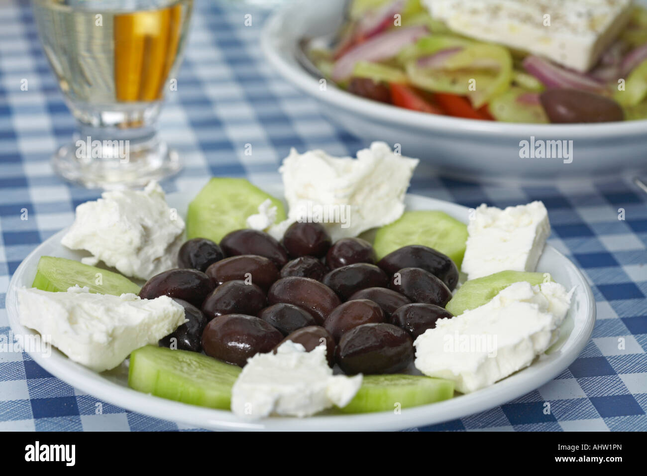 Plate with olives feta and cucumber on table Greek salad and retsina in ...