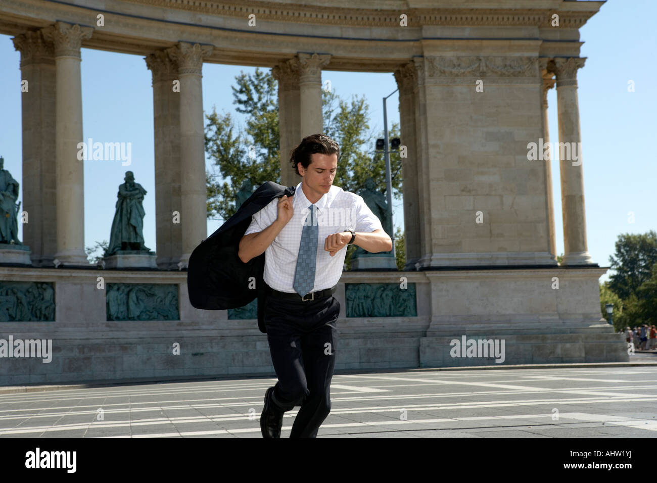Businessman running looking at watch Stock Photo - Alamy