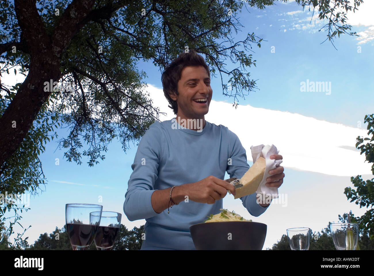 Young man shaving parmesan on pasta Stock Photo - Alamy