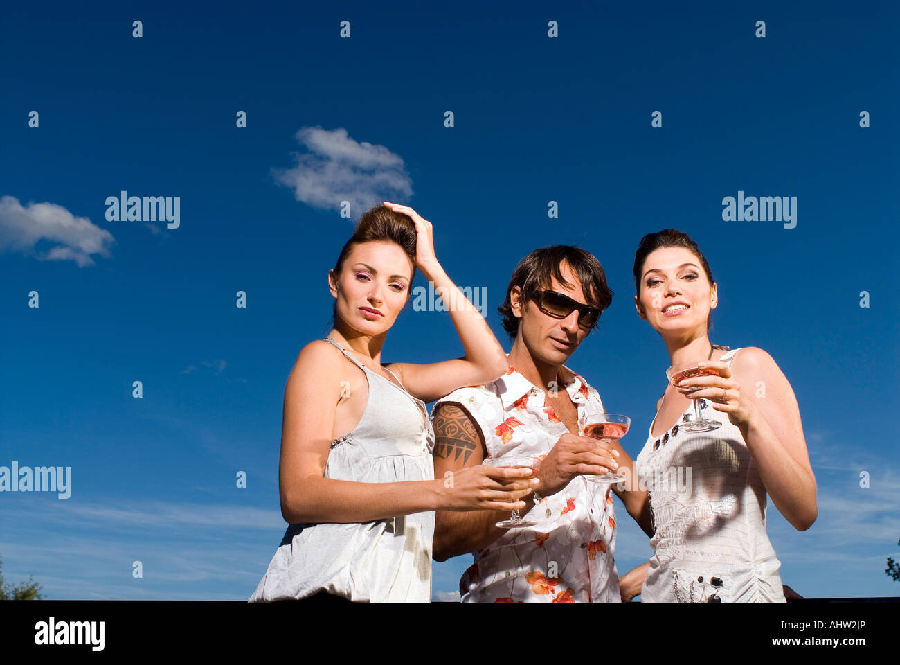 Three people with drinks outdoors Stock Photo - Alamy