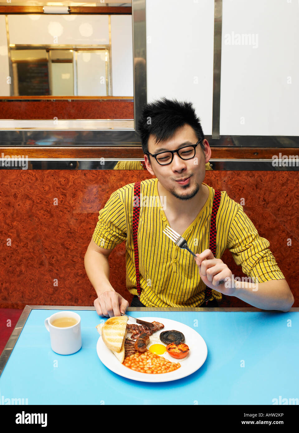 Young man eating fried meal in diner alone Stock Photo - Alamy