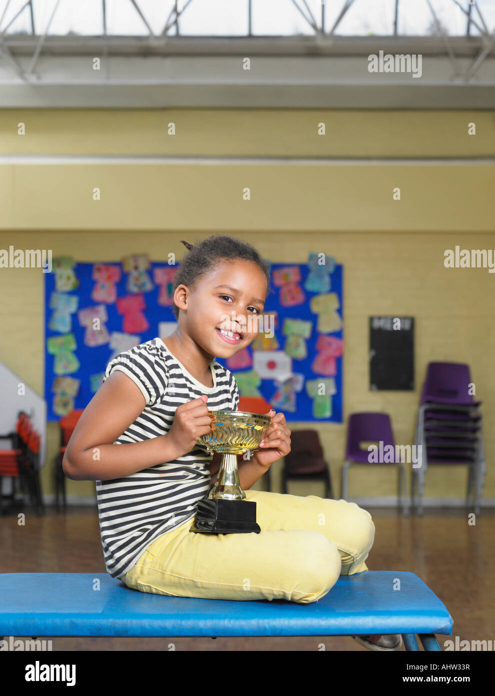 Young girl with trophy in school hall Stock Photo - Alamy