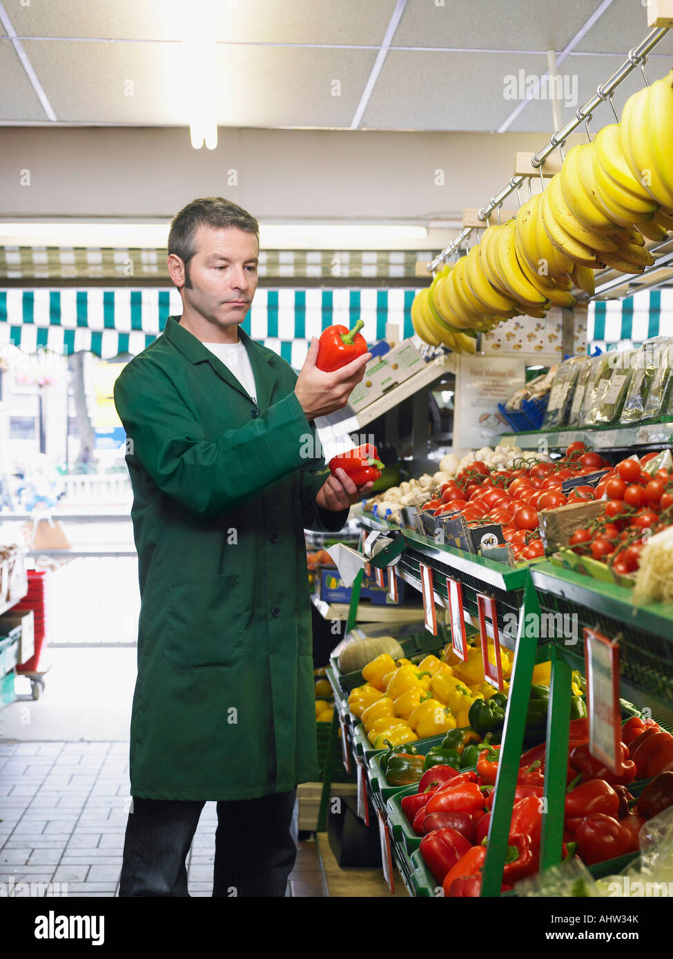 Grocer checking quality of produce Stock Photo - Alamy